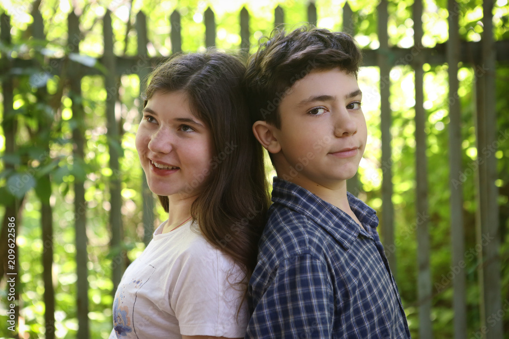 two siblings teenager kids sister and brother measure height each other ...