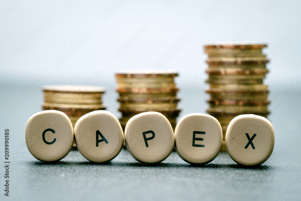 CAPEX letter block and stack coins, business concept. CAPEX stands for ...