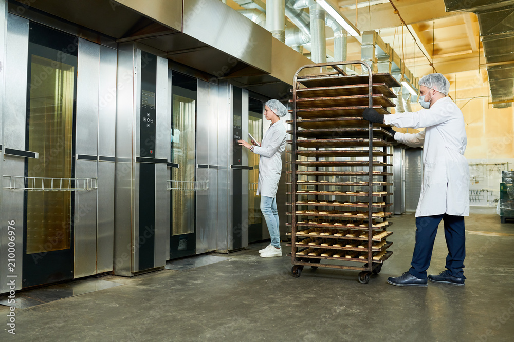 Confectionery factory employees in white coats waiting for elevator to ...