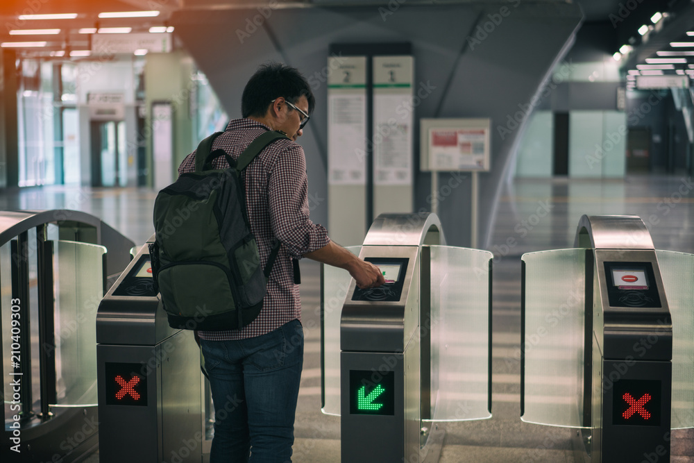 Young asian traveler using smart card pass the door at Mass Rapid ...