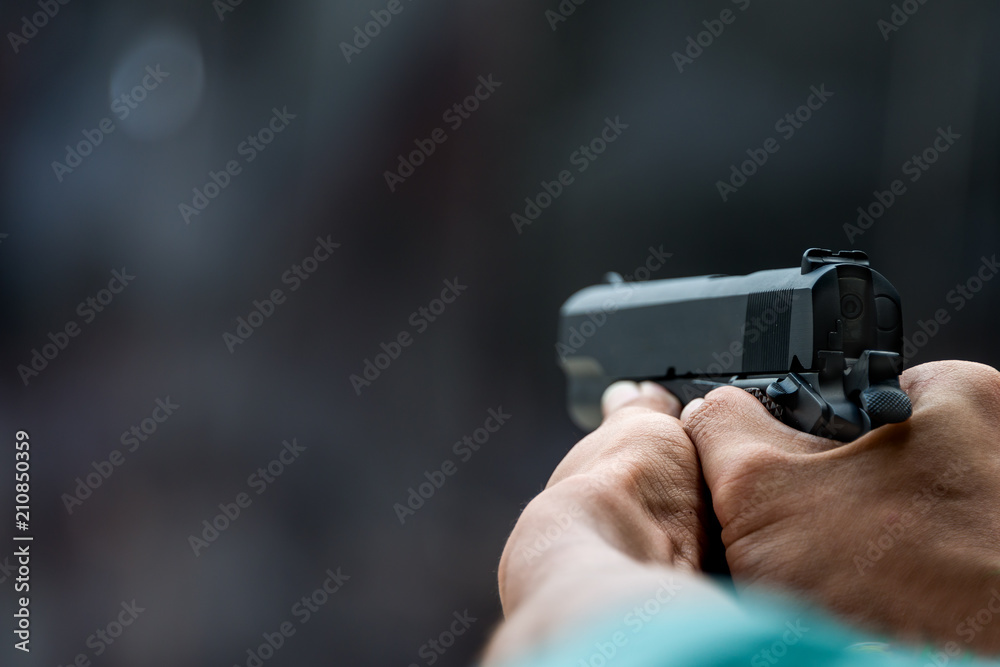 Man aiming gun pistol in shooting range. Stock Photo | Adobe Stock