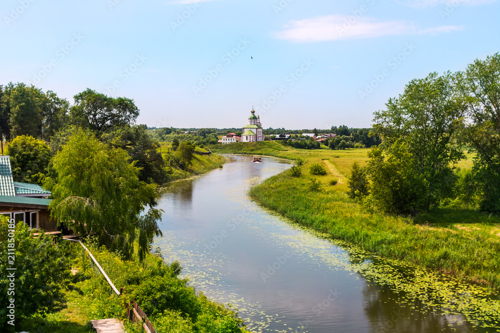 Suzdal landscape. Beautiful view of the river Kamenka, green field and ...