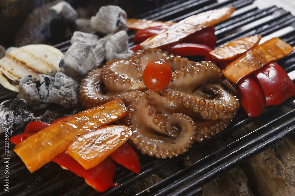 Grilled octopus served with carrot, pepper and onion. Octopus is a ...