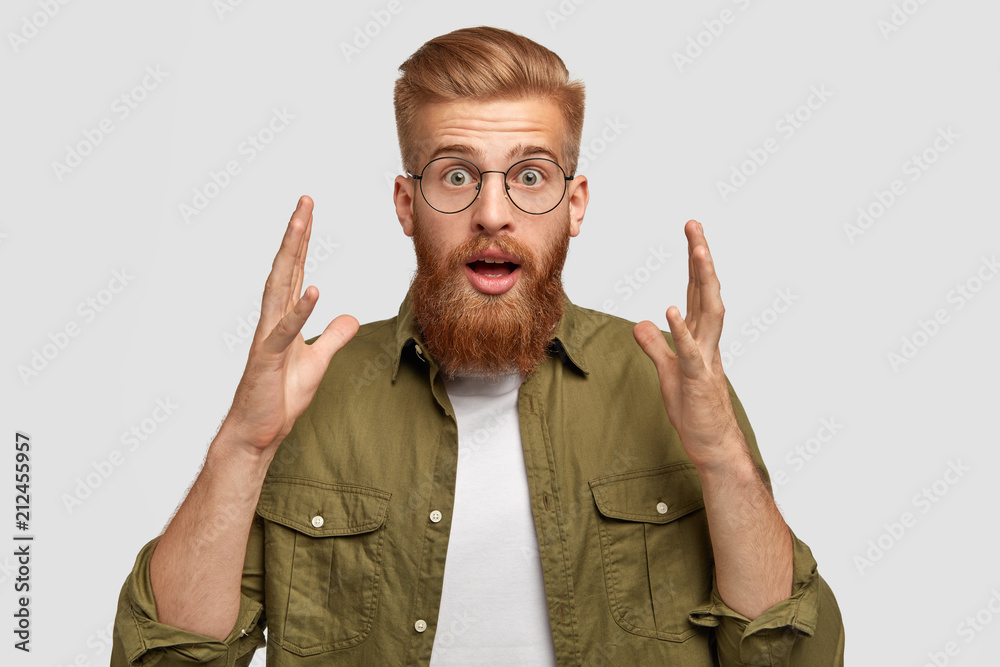 Стоковое фото «Amazed puzzled red haired male with astonished ...