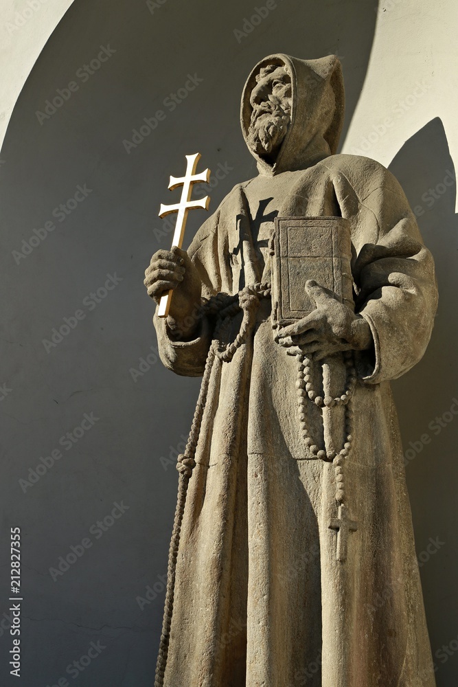 Statue of St. Francis Seraph holding a bible, rosary beads and a golden ...