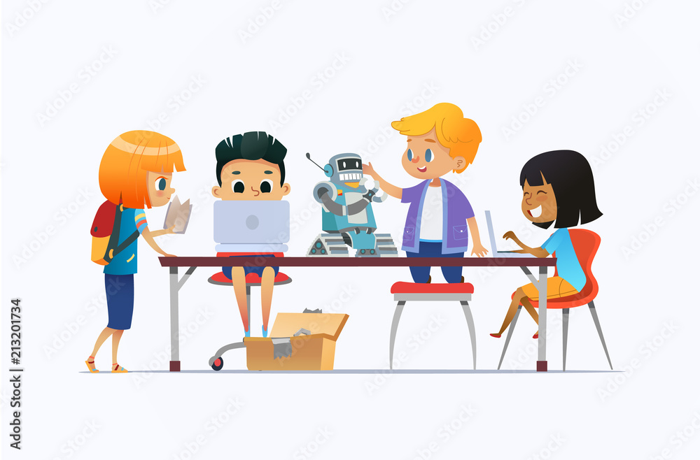 Boys and girls standing and sitting around desk with laptops and robot ...