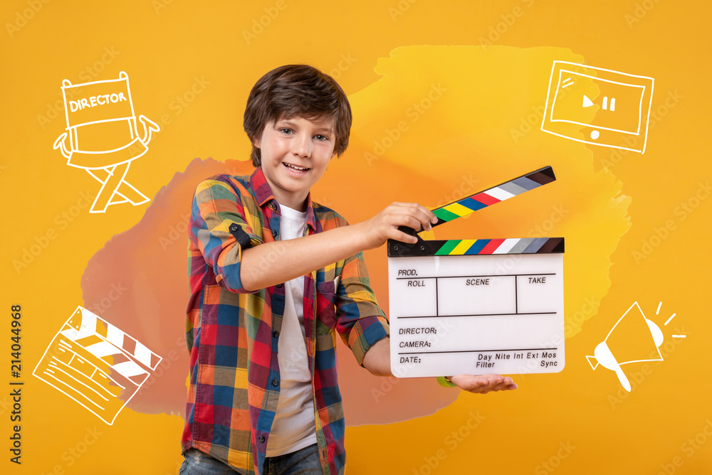 Film director. Positive emotional boy feeling excited and smiling while ...