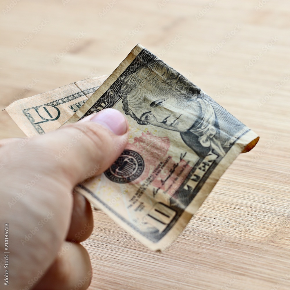 A Caucasian hand holding a USA ten dollar note. This image can be used ...