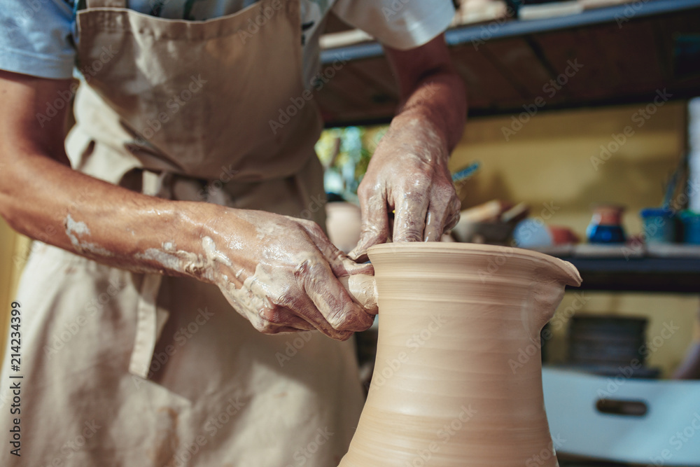 Creating a jar or vase of white clay close-up. Master crock. Man hands ...