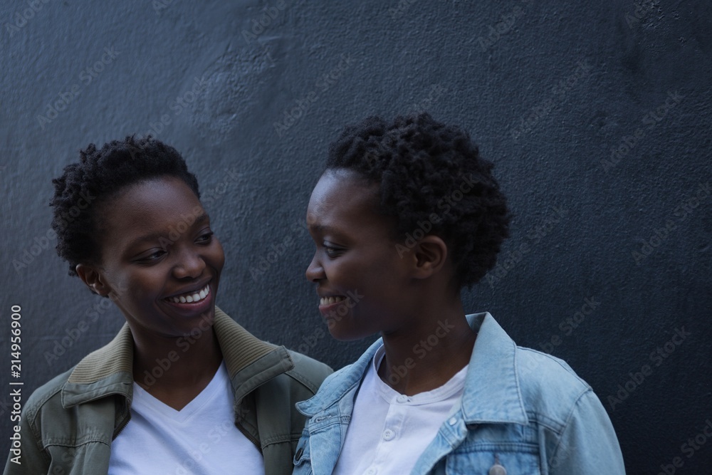 Smiling siblings standing against black background Stock Photo | Adobe ...