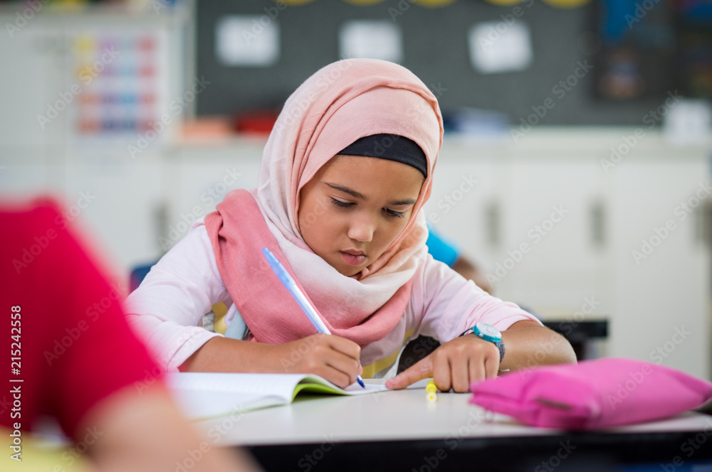 Young girl wearing hijab studying Stock Photo | Adobe Stock