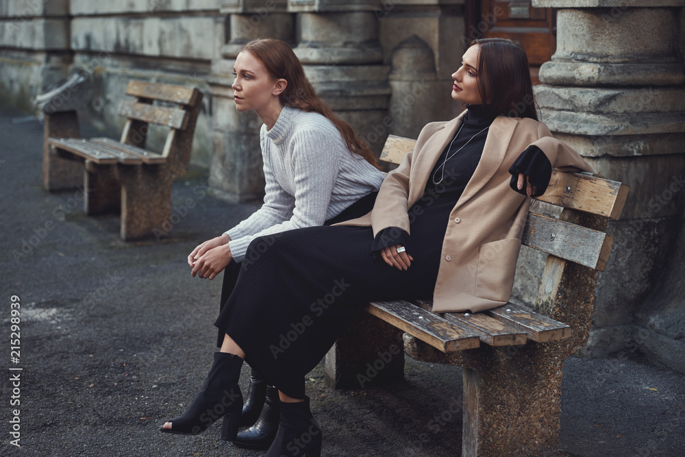 Fashion models sitting on bench in city Stock Photo | Adobe Stock