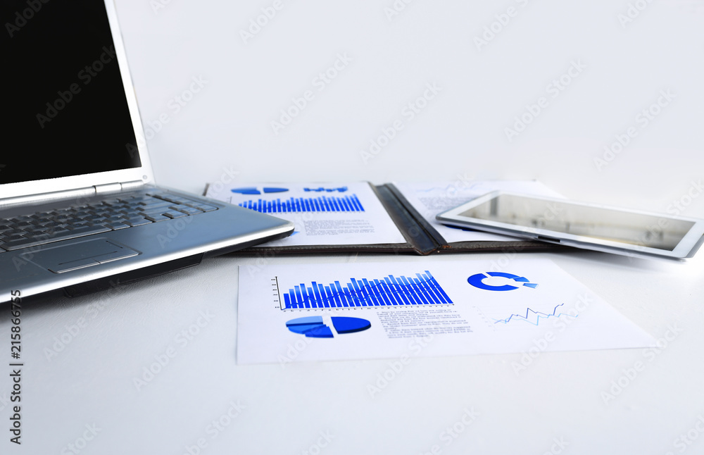 Financial chart, laptop and tablet on the workplace of a businessman ...