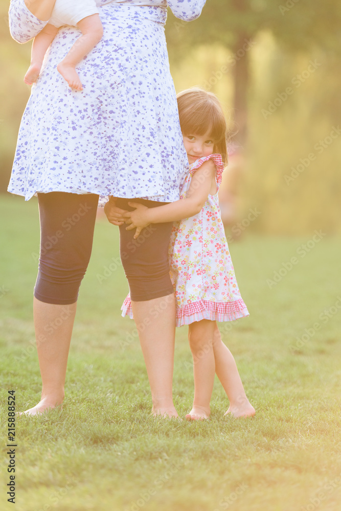 Shy little girl hiding behind her mother Stock Photo | Adobe Stock