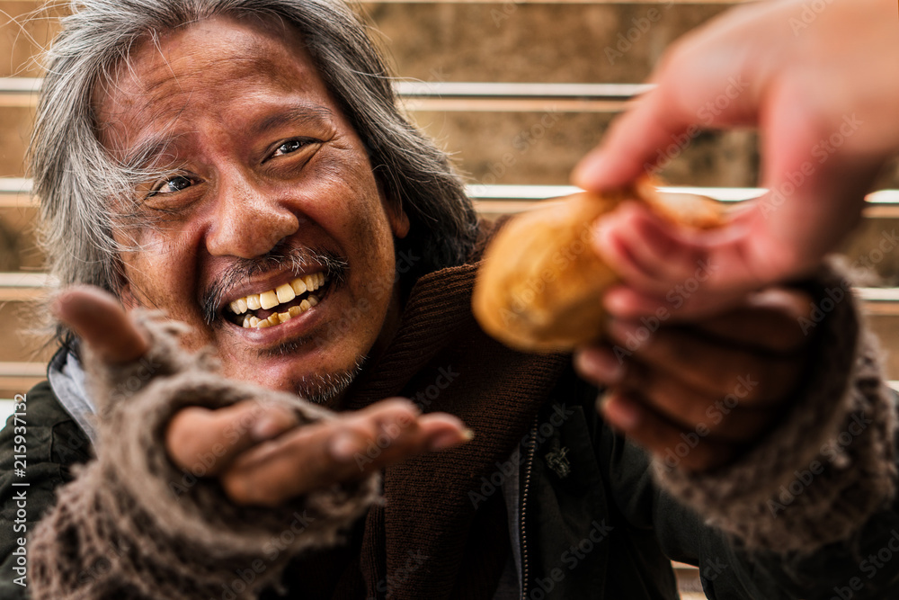 Homeless male with happy face showing hands to recieve bread from ...
