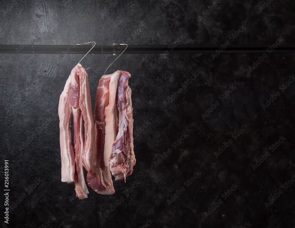Pork hanging on hook against dark background,Pork belly Stock Photo ...