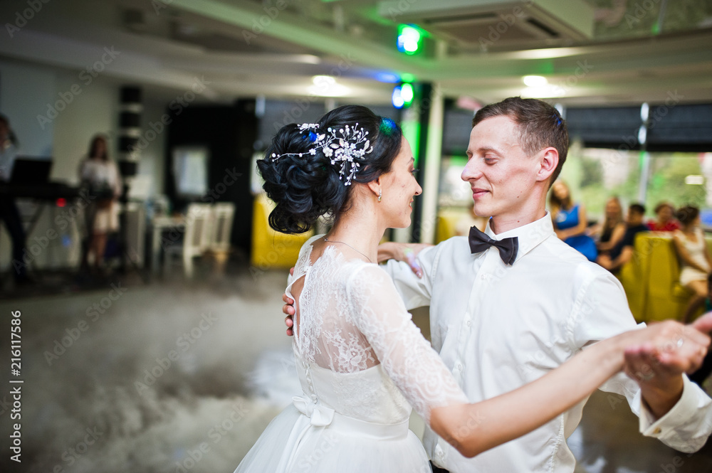 Romantic newly married couple performing their first dance in the ...