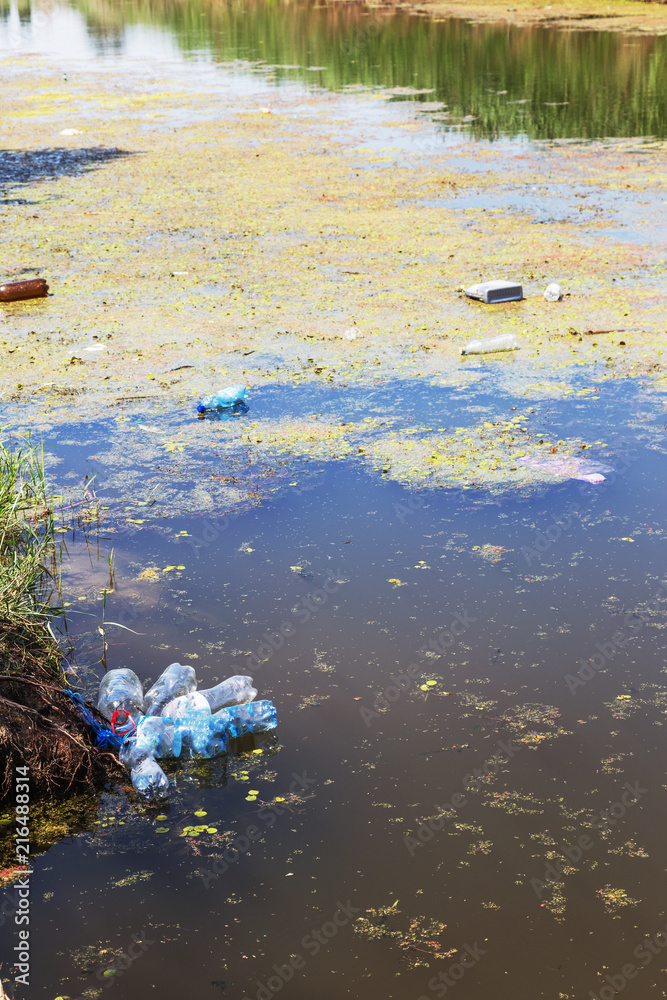 Dirty sewage and household rubbish in small river, irrigation channel ...