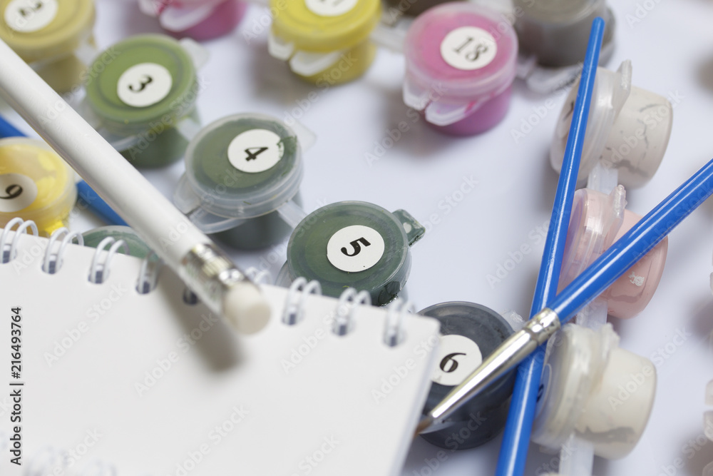 Numbered containers with paints and brushes of different sizes. For ...