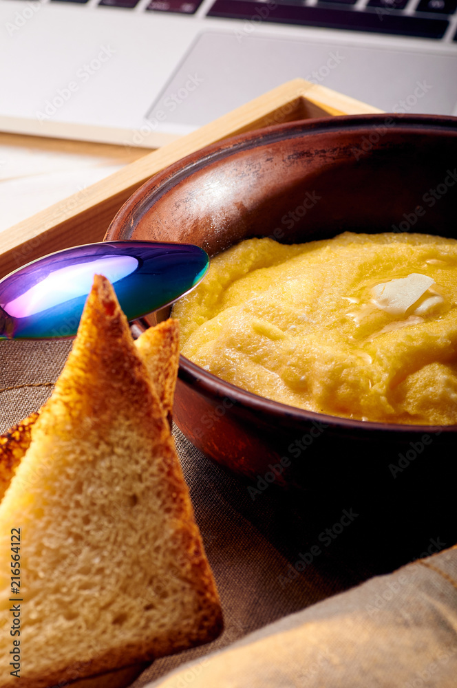 Polenta with butter and some crispy toast. Eating is served on a tray ...