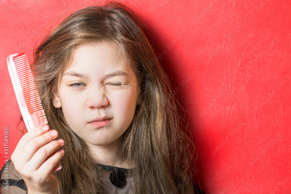 Beautiful girl shows a comb with a closed eye on a red background Stock ...