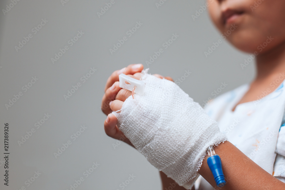 Sick asian child girl hand who have saline intravenous (iv) drip ...