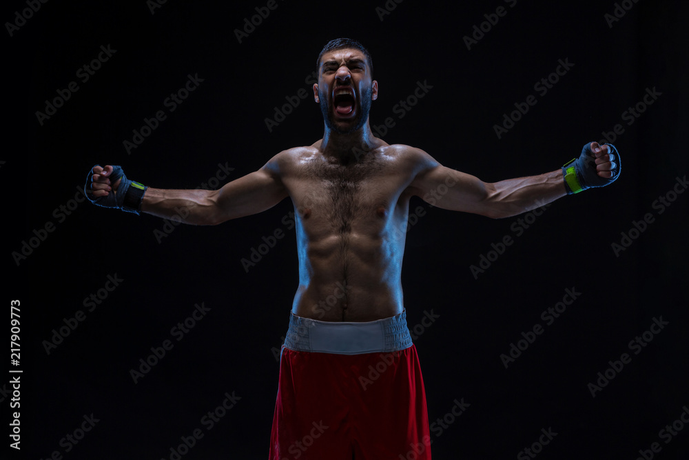 Oriental boxer celebrating his victory with raised arms in black gloves ...