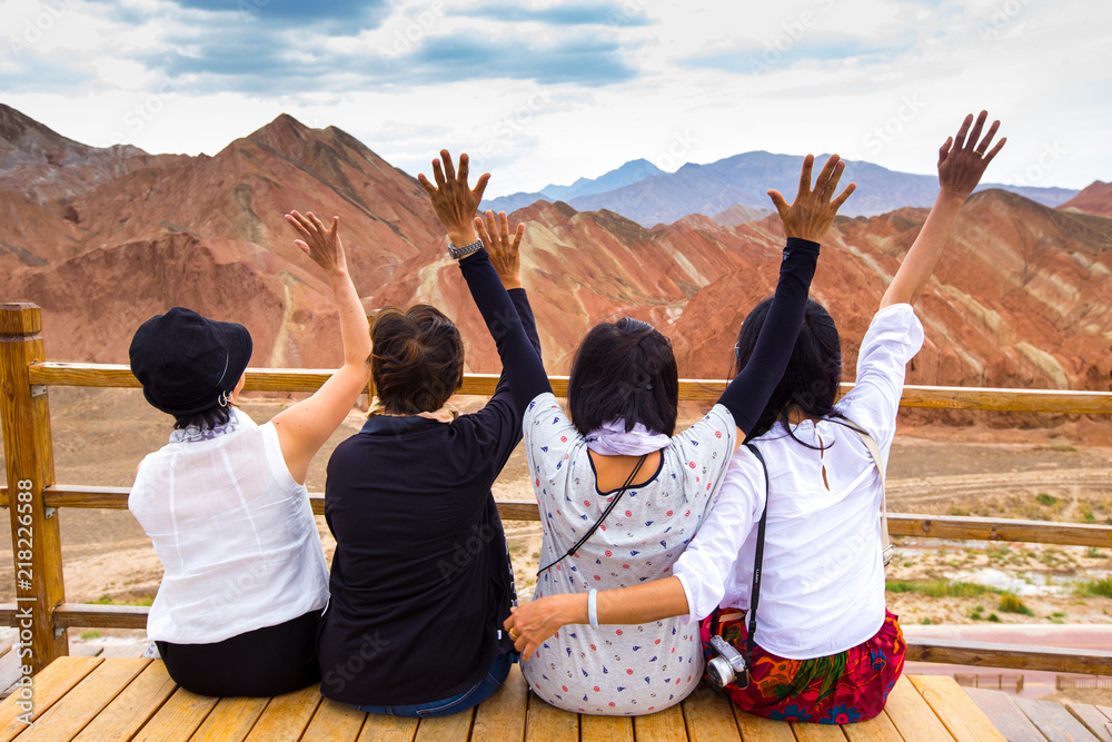 Back side rear View of Happy Friends Sisters sitting with raised Hands ...