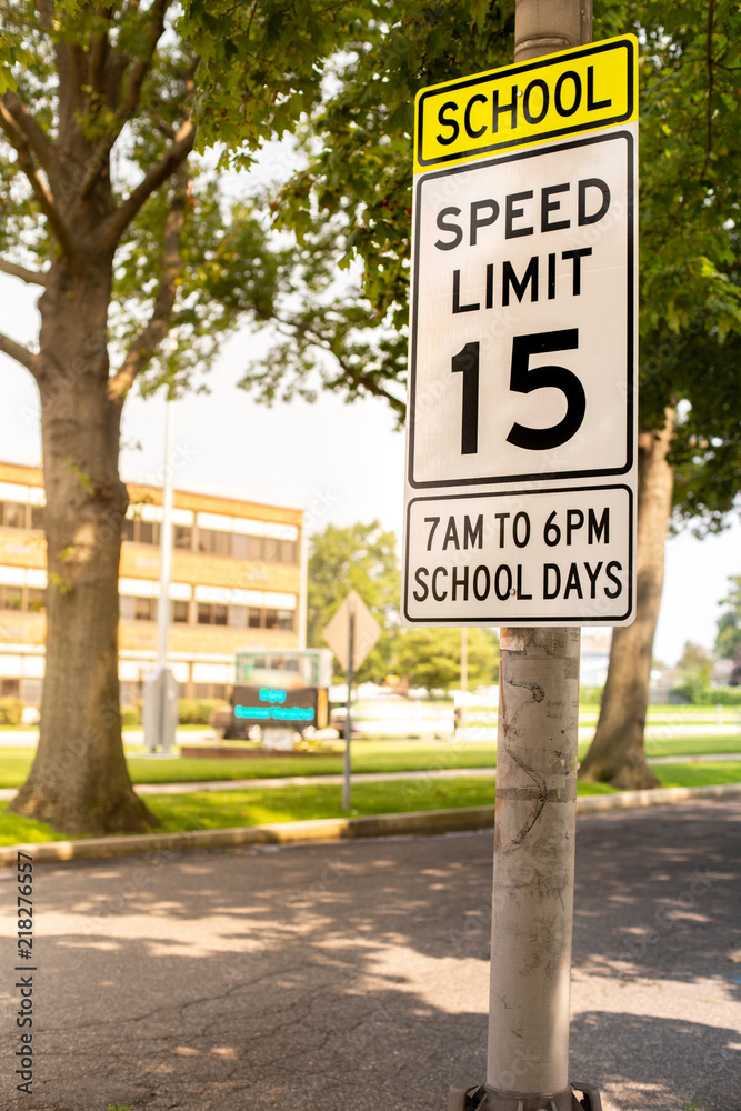 Sign indicating school zone speed limit of 15 miles per hour with ...