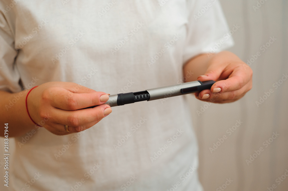 Diabetes patient turn knob on end of insulin pen and dial up correct ...