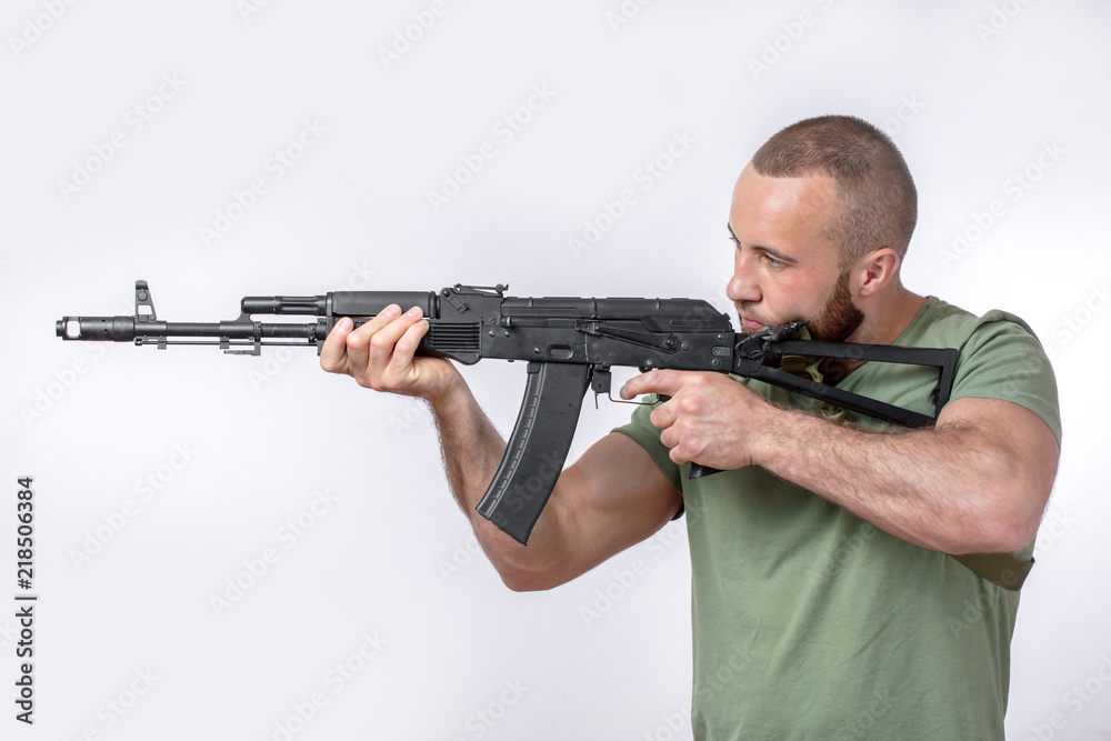 Strong caucasian shooter in casual clothing with sniper rifle standing ...