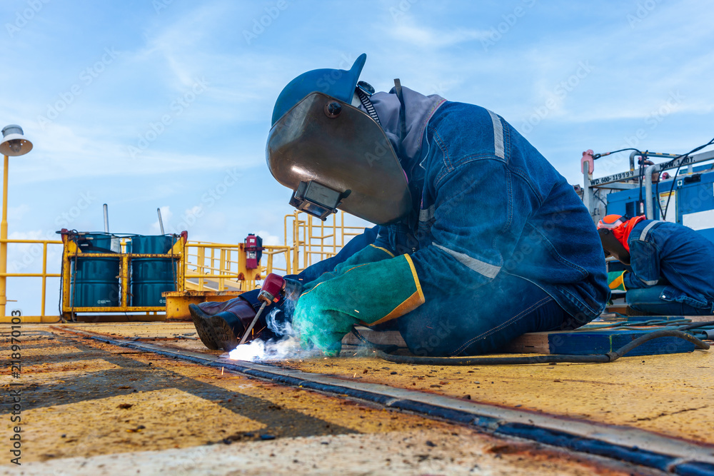 Industrial welder worker holding welding torch during perform welding ...