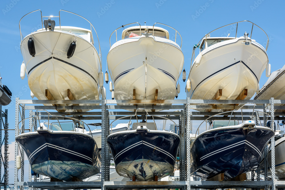 View from below of the hulls of motorboats racked one above another on ...
