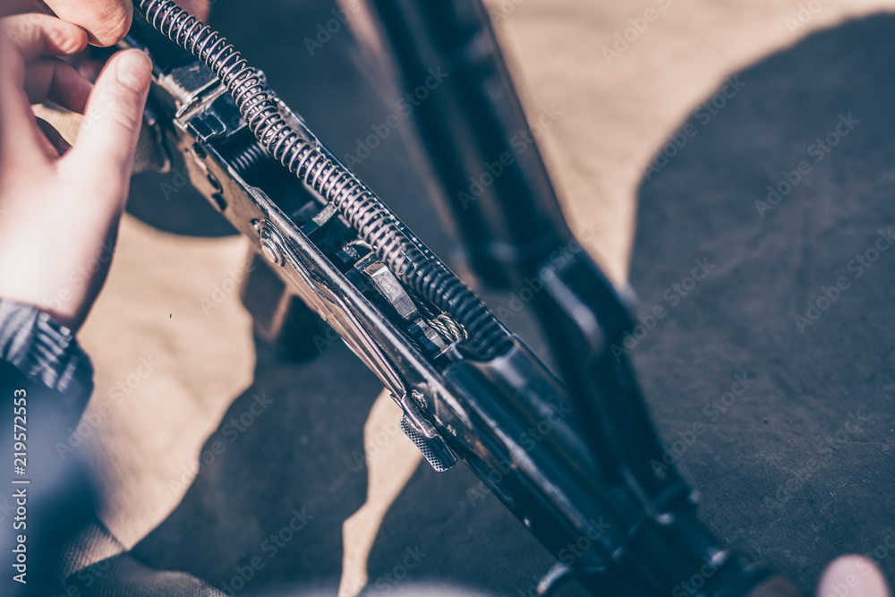 The boy performs disassembly, cleaning and assembly of AK-47, an ...
