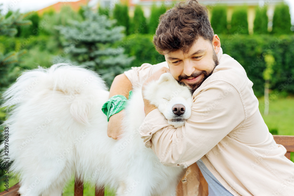 Hugging dog. Loving owner of cute white husky feeling extremely happy ...