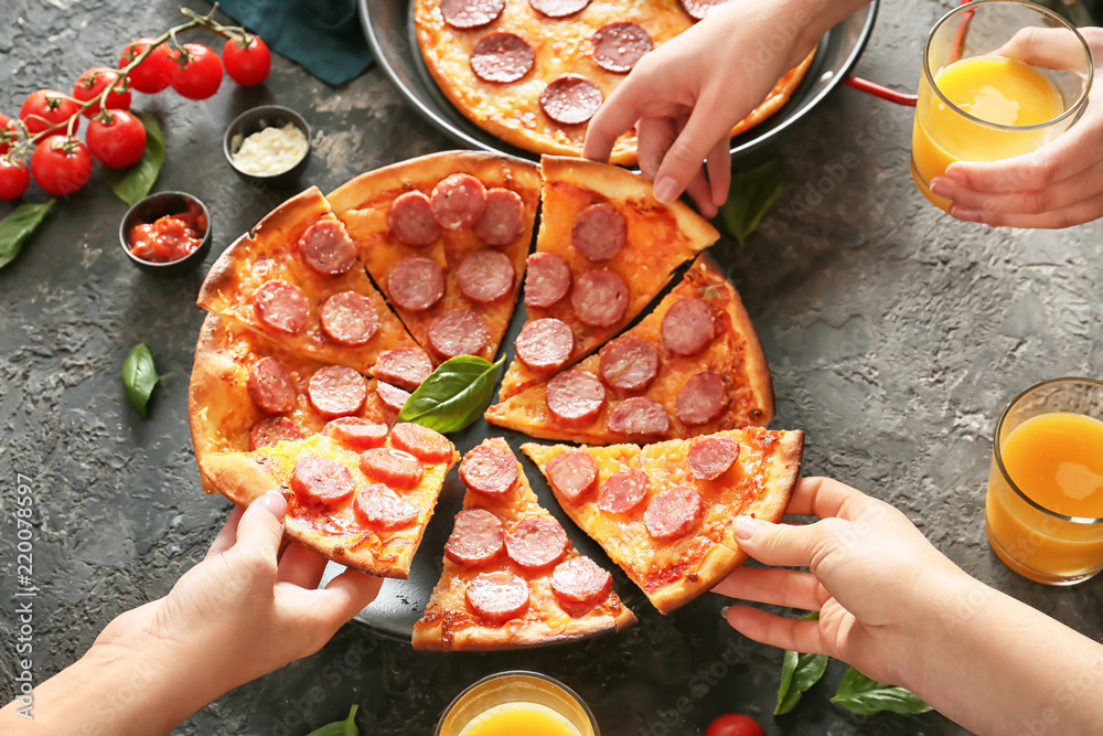Young people eating tasty pizza at table Stock Photo | Adobe Stock