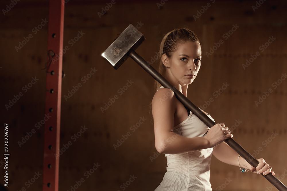 Fitness woman with a hammer in the gym. Portrait of attractive girl ...