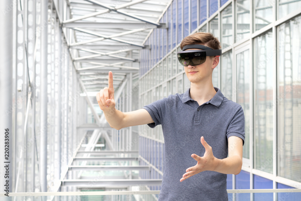 Portrait of young Caucasian teenager using augmented reality HoloLens ...