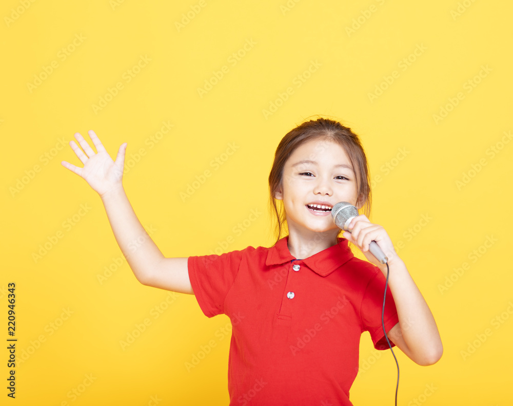 happy little girl singing on yellow background Stock Photo | Adobe Stock