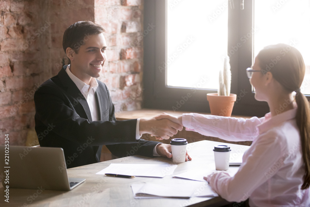 Smiling young male and female handshake. Businesspeople shaking hands ...