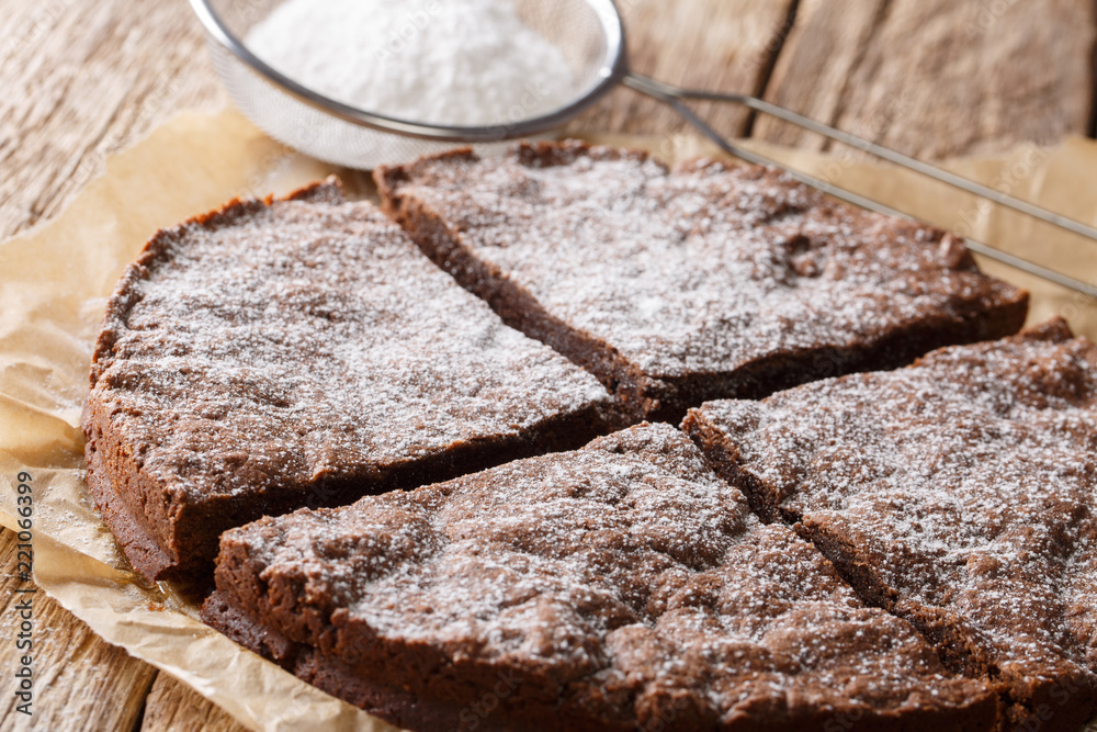 Swedish chocolate sticky cake with powdered sugar close-up on the table ...