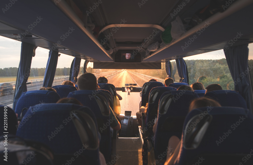 Bus with people going on the road in the evening at sunset. Photo ...