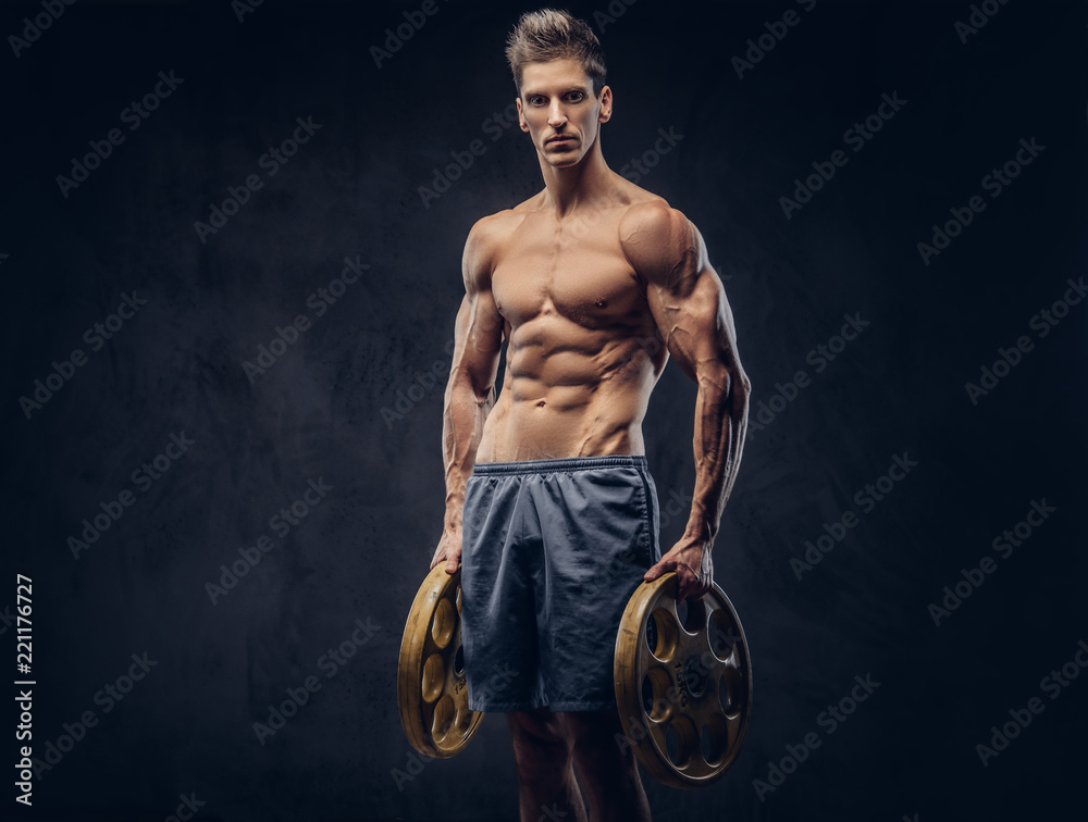 Handsome shirtless ectomorph bodybuilder with stylish hair posing with ...