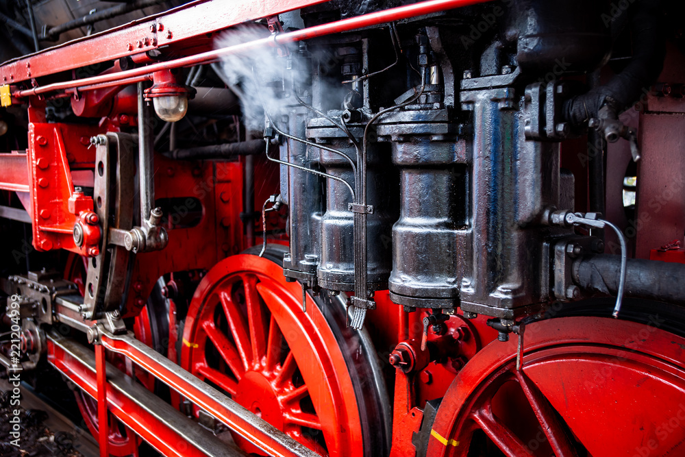 Steaming and moving old locomotive with red steel wheels on on-site ...
