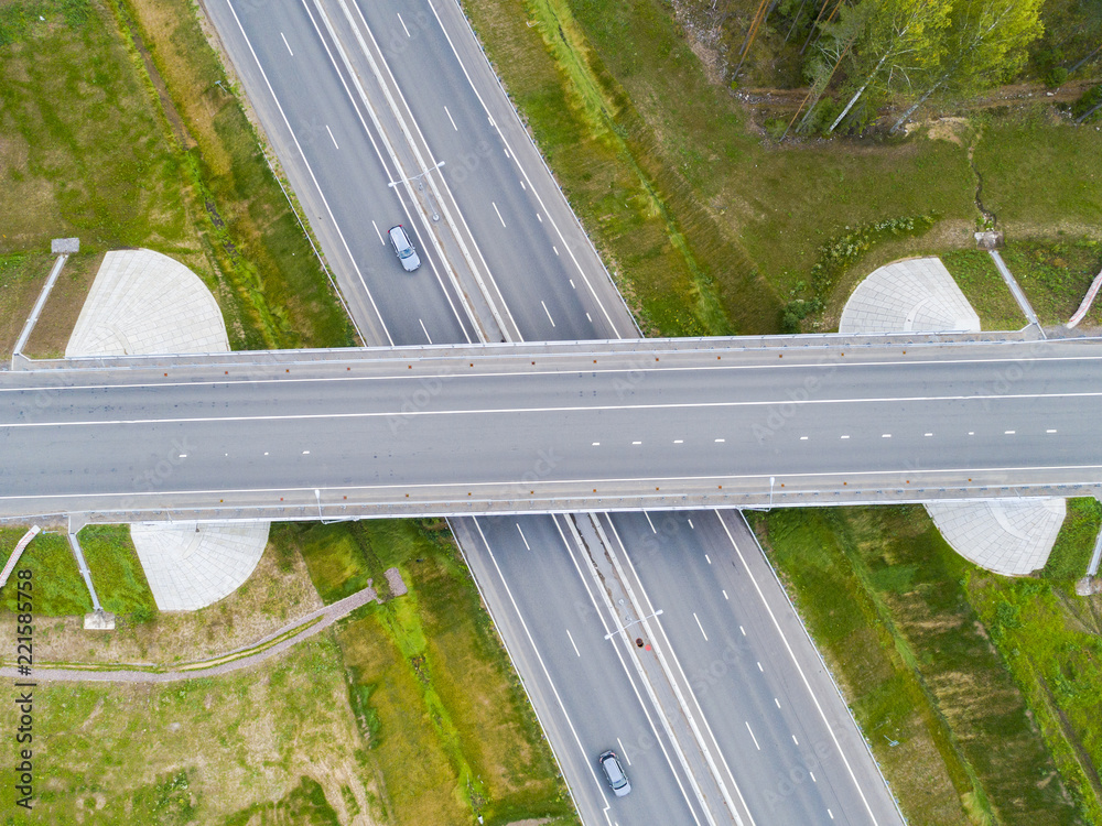 Aerial view of highway in city. Cars crossing interchange overpass. Highway interchange with ...