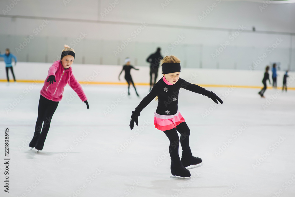 Little girls learning to ice skate. Figure skating school. Young figure ...