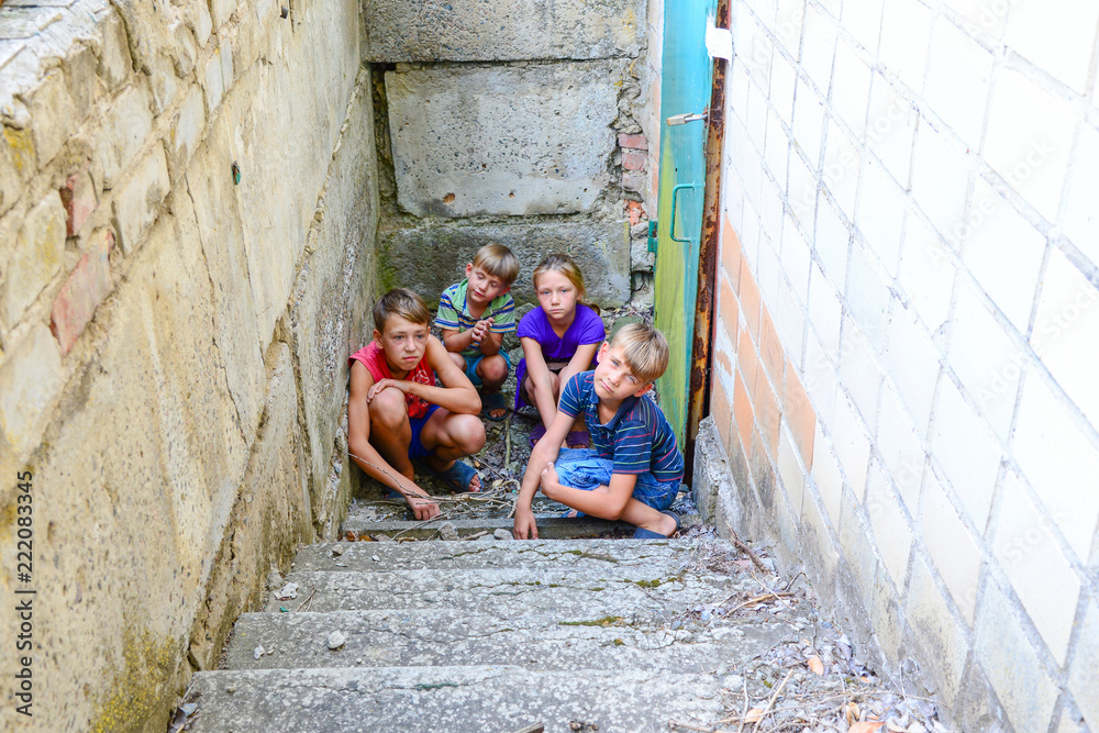 Children in the basement, three boys and a girl near the iron door are ...