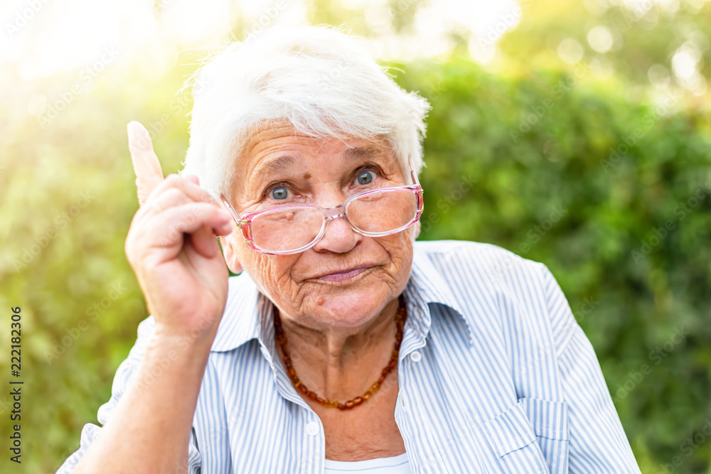 beautiful old lady, Granny with glasses shows index finger, warns ...