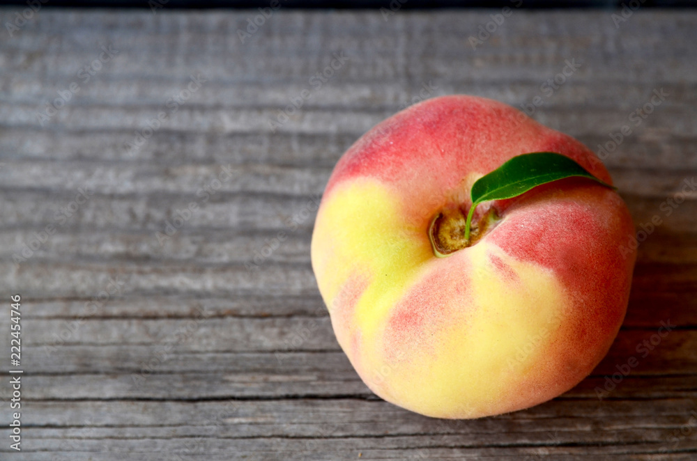 Photo Stock Chinese flat peach with leaves on old wooden table.Donut ...
