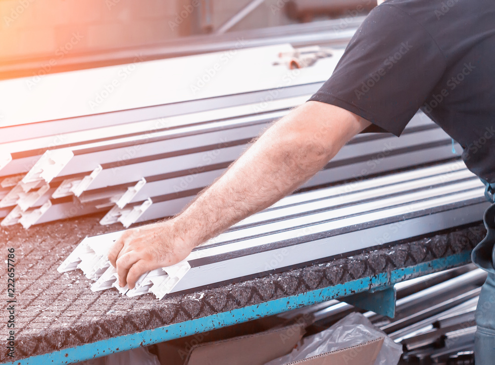 Production of pvc windows, a man removes measurements from a pvc frame ...